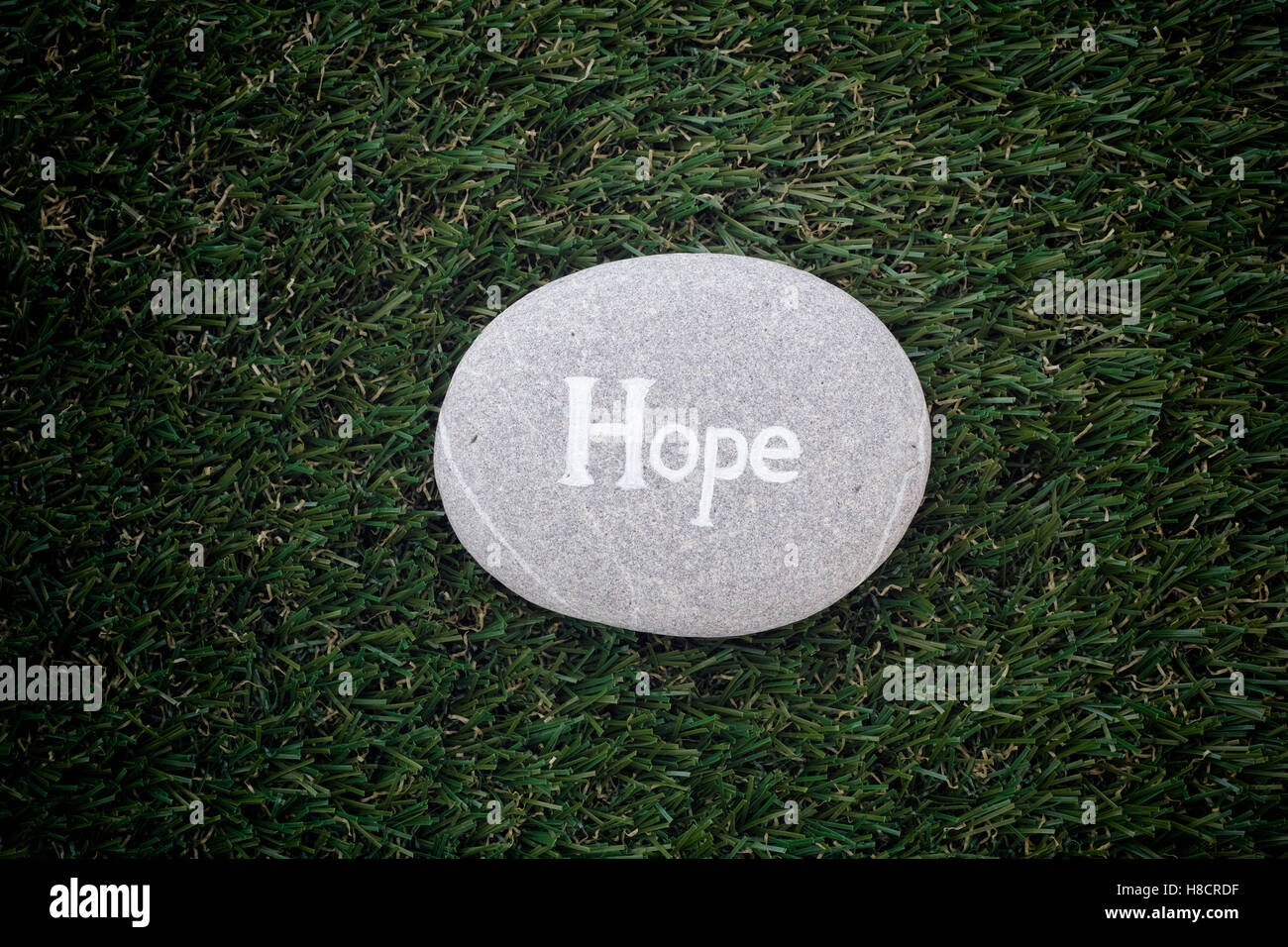 Hope. Stone with word Hope lying on green grass. Close up Stock Photo ...