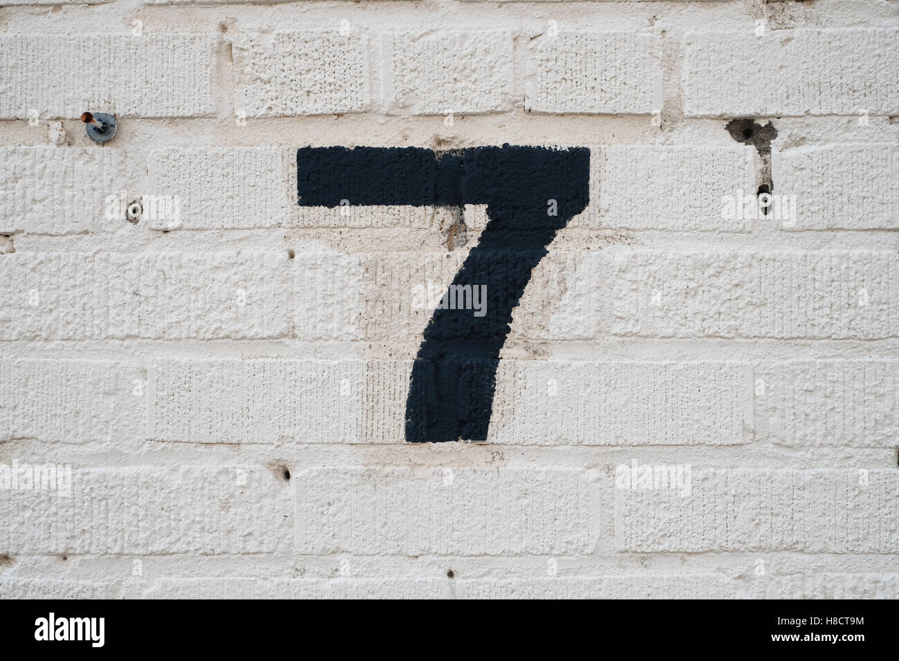 Number 7, seven painted in black on white brick Stock Photo - Alamy
