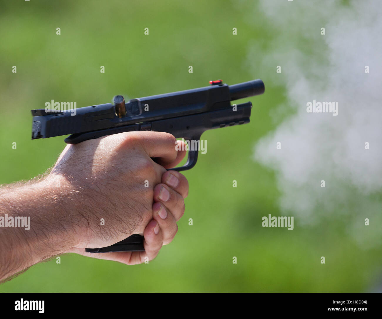 Pistol that has been shot and is ejecting the brass Stock Photo - Alamy