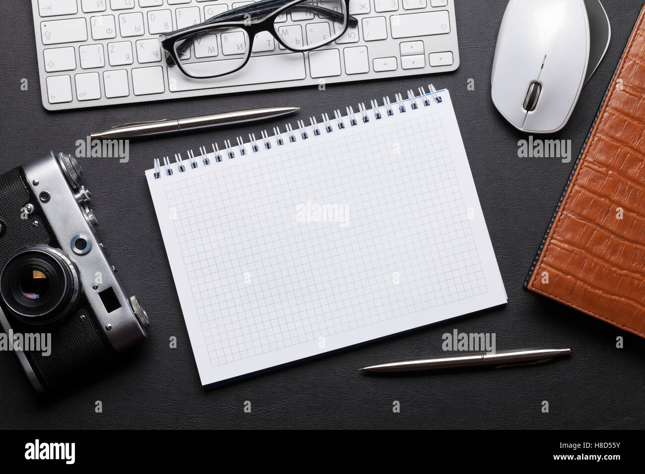 Office desk with photo camera, pc, notepad, glasses, pen and pencil ...