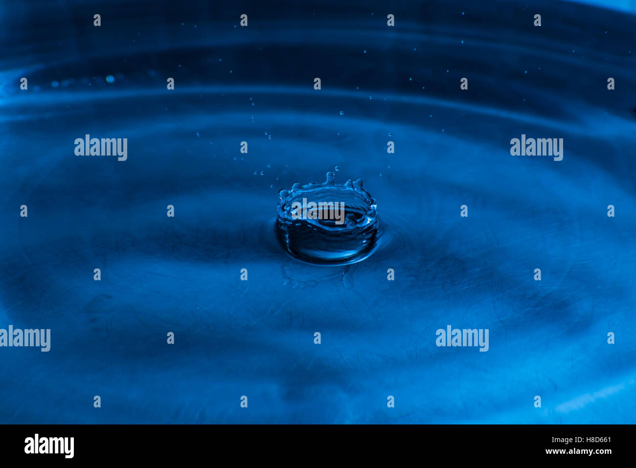 Water drop falling into water making a concentric circles Stock Photo ...