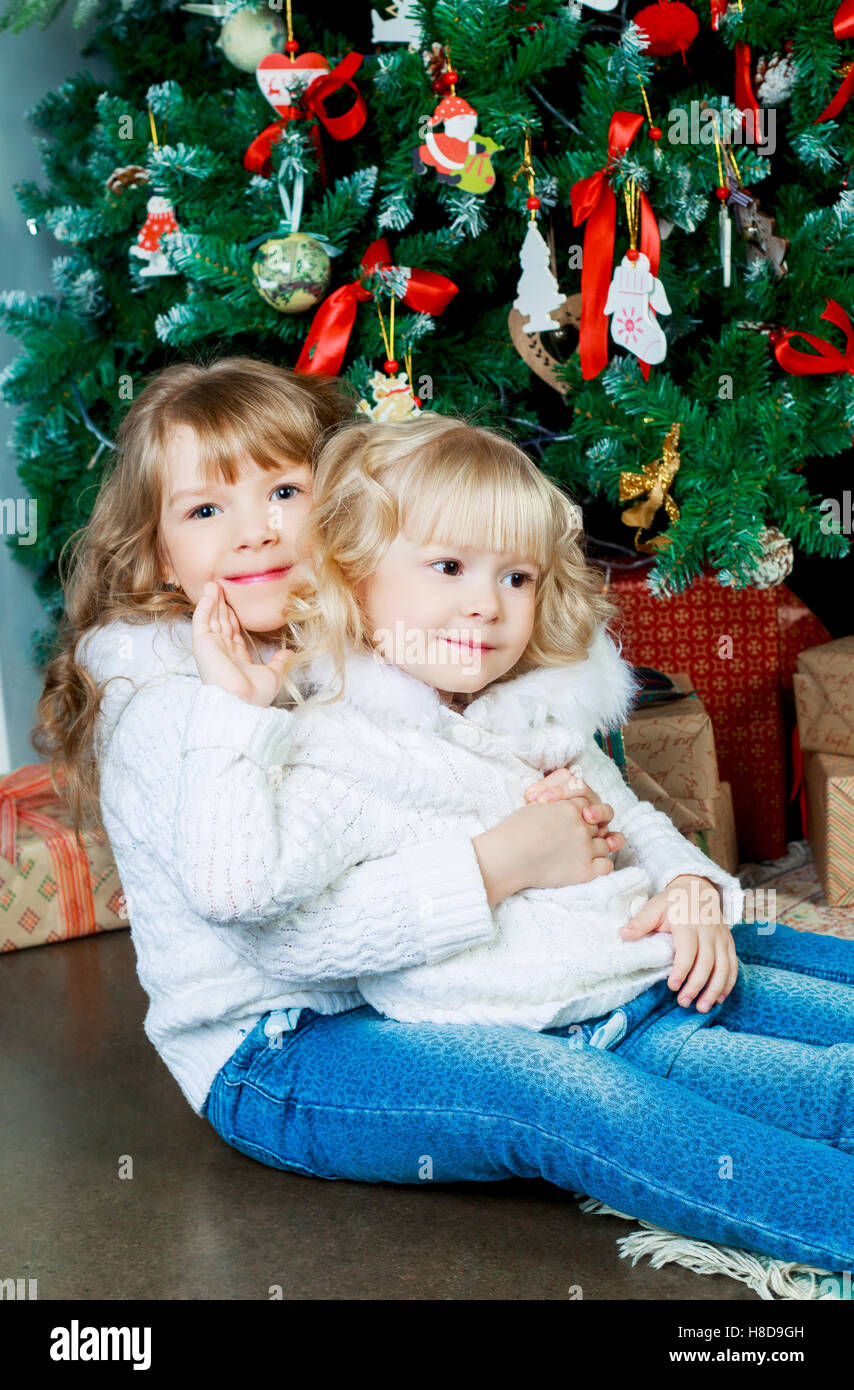 two happy sisters at home with Christmas tree Stock Photo - Alamy