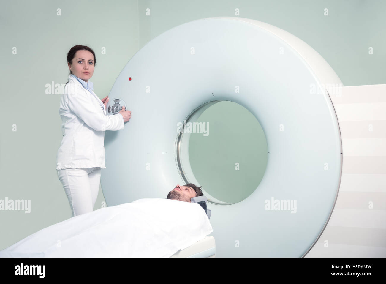 Mid adult nurse preparing patient for CT scan test in hospital room ...