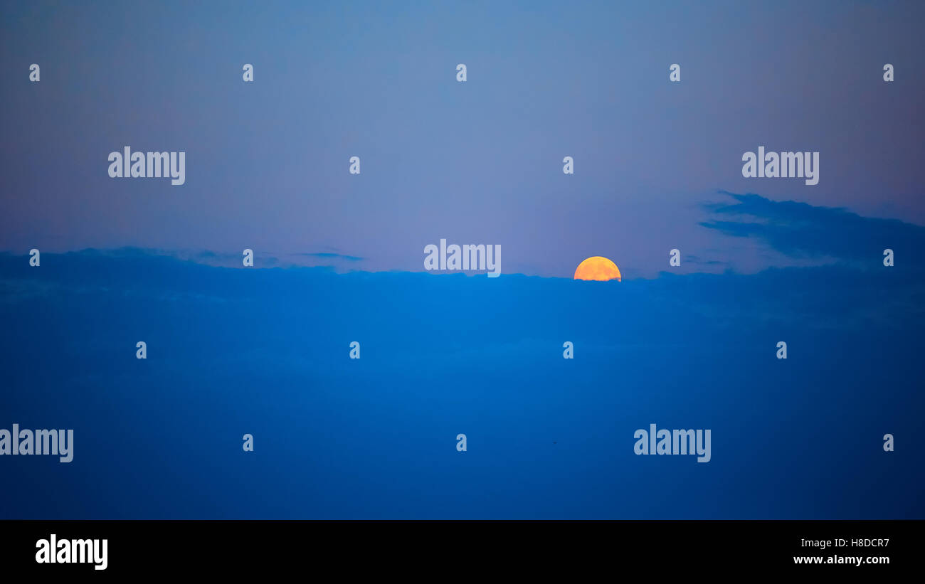 Full moon at sunset Stock Photo - Alamy