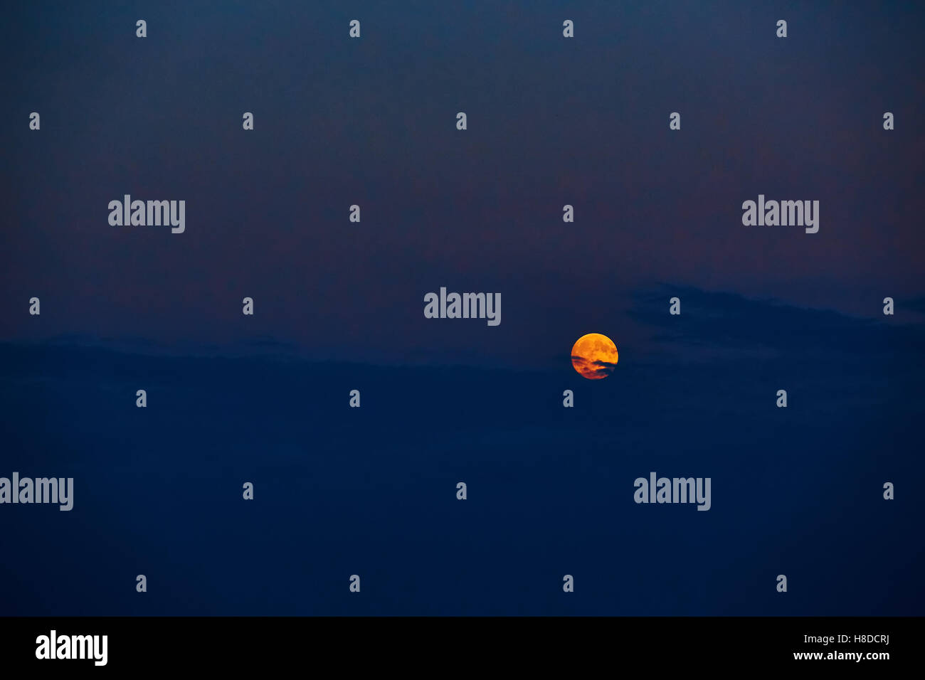 Full moon at sunset Stock Photo - Alamy