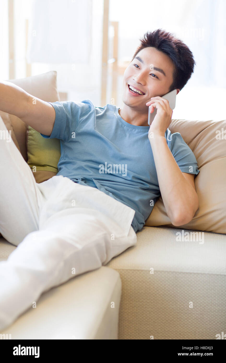 Young Chinese man talking on cell phone at home Stock Photo - Alamy