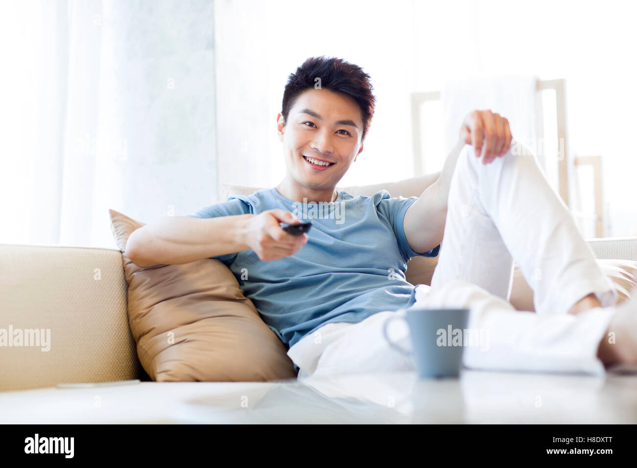 Young Chinese man watching TV at home Stock Photo - Alamy