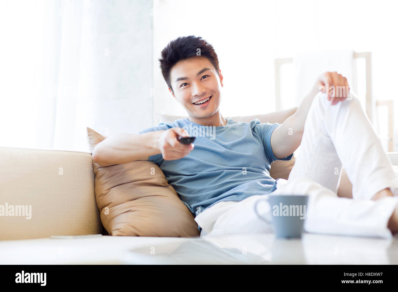 Young Chinese man watching TV at home Stock Photo - Alamy