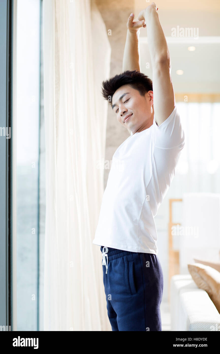 Young Chinese man stretching at home Stock Photo - Alamy