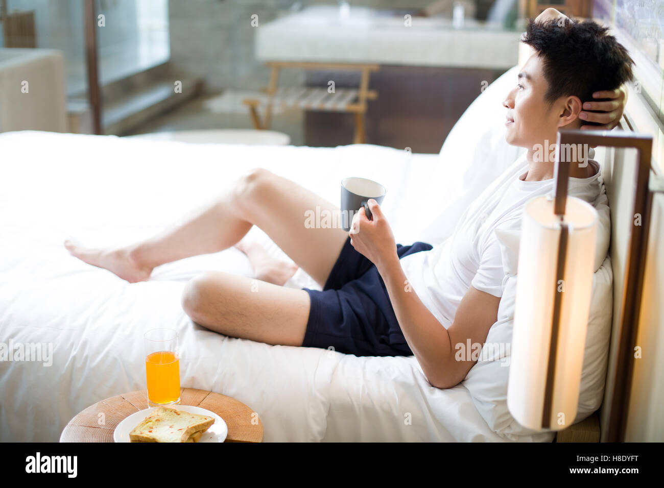 Young Chinese man drinking coffee at home Stock Photo - Alamy