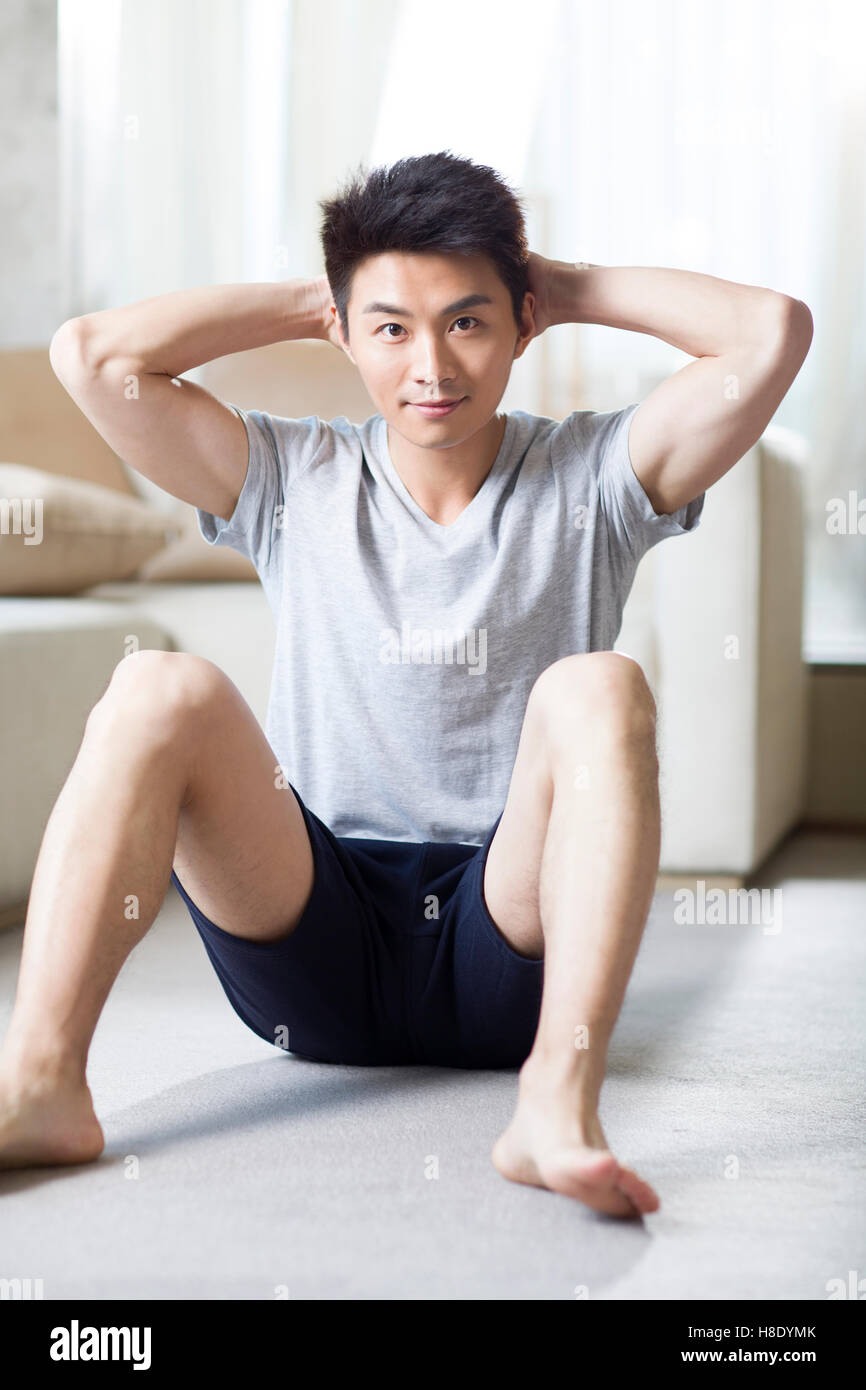 Young Chinese man exercising at home Stock Photo - Alamy