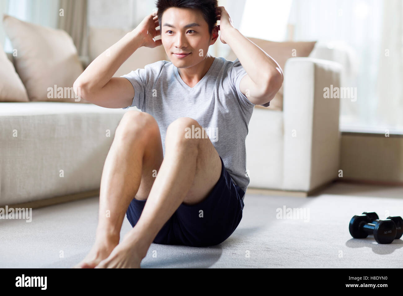 Young Chinese man exercising at home Stock Photo - Alamy