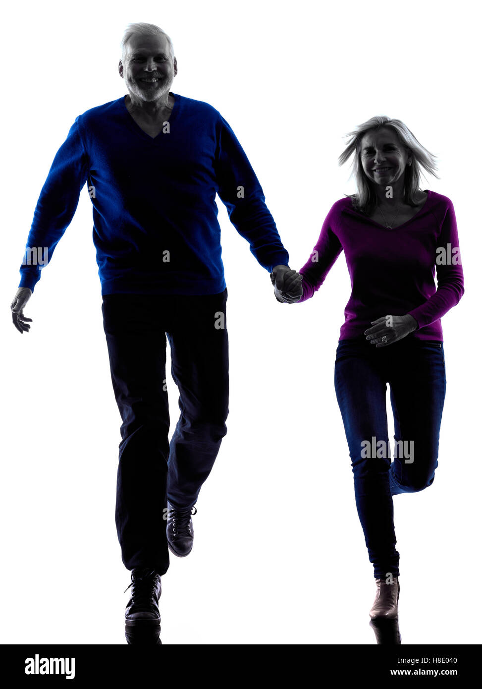 one caucasian couple senior running happy silhouette in silhouette ...