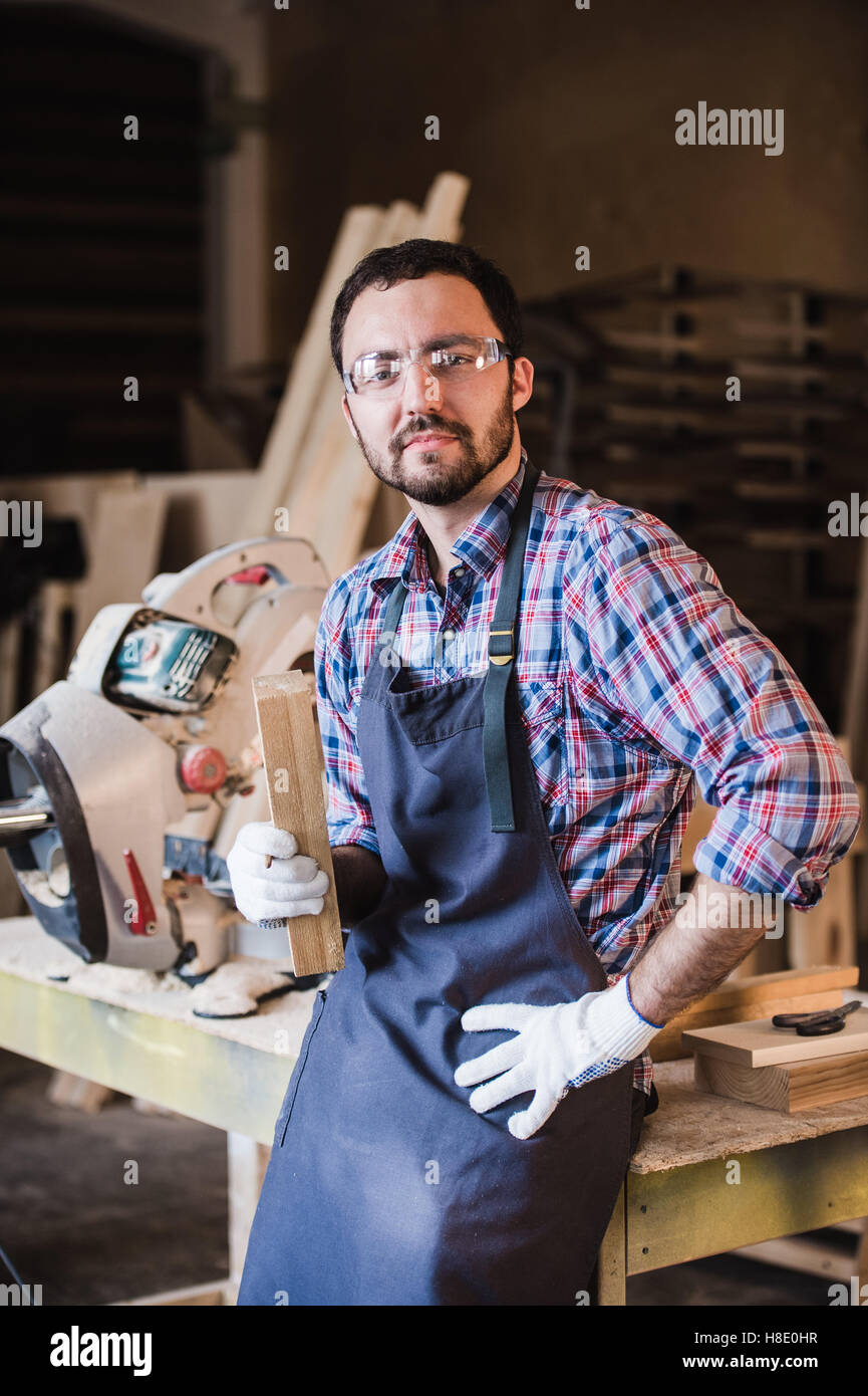 Happy young handyman carpenter in workshop, smiling Stock Photo - Alamy