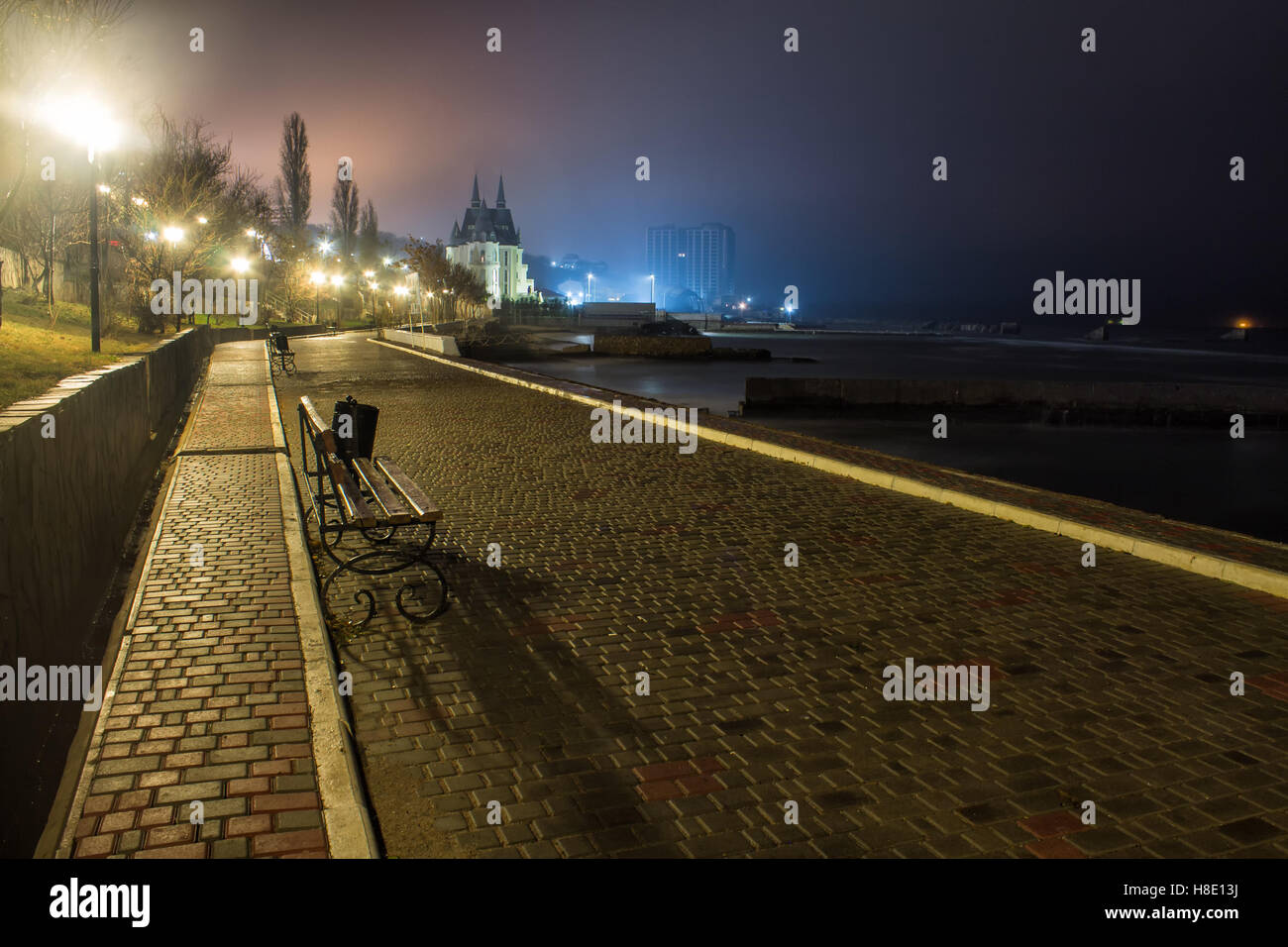 Amazing night street view with lights after rain. Sea and castle on ...