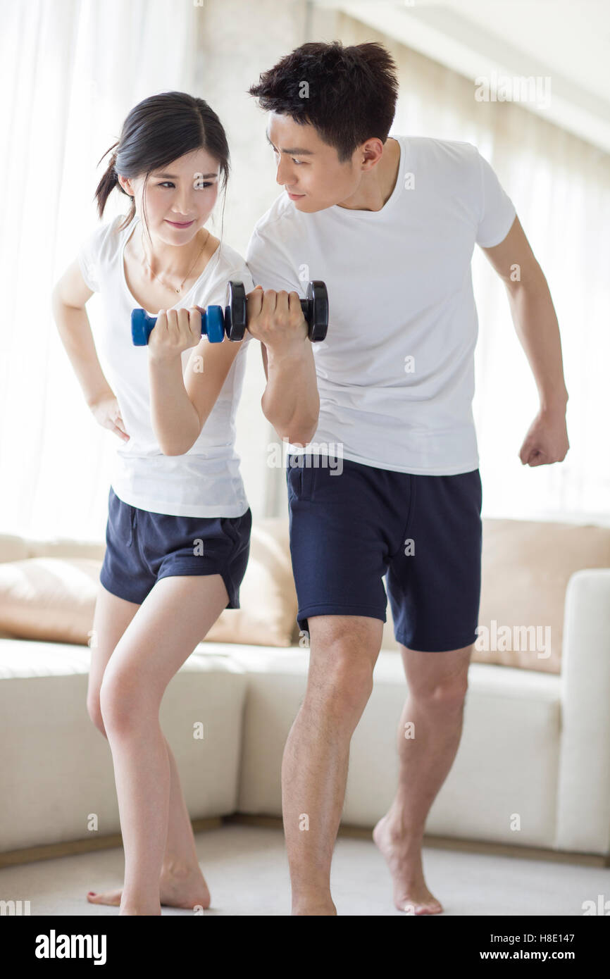 Young Chinese couple exercising at home Stock Photo - Alamy