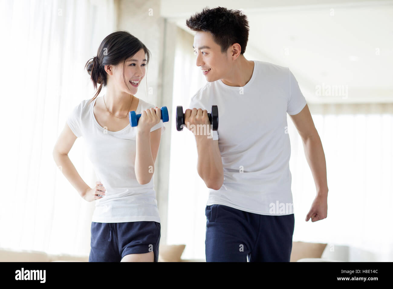 Young Chinese couple exercising at home Stock Photo - Alamy