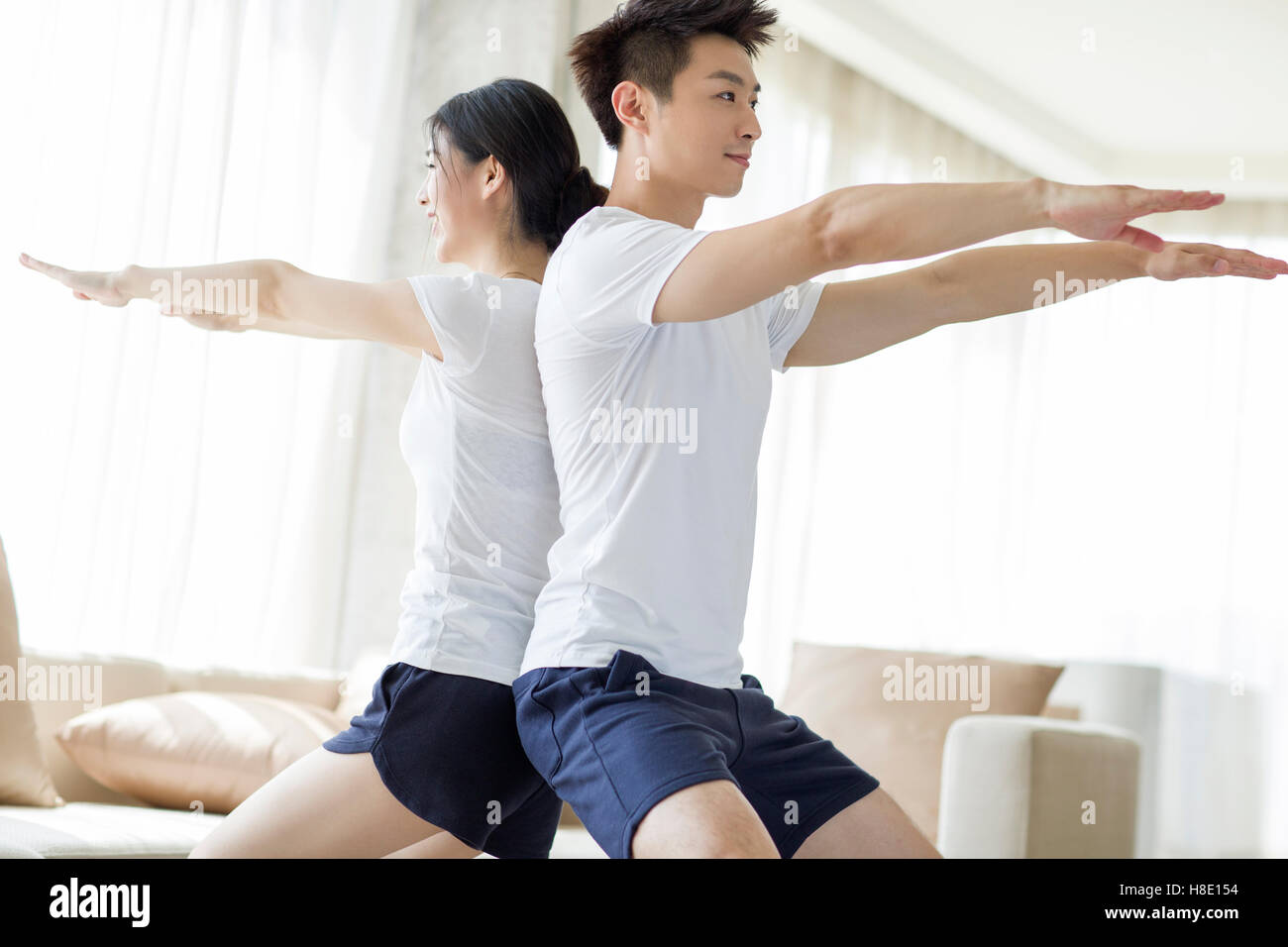 Young Chinese couple exercising at home Stock Photo - Alamy