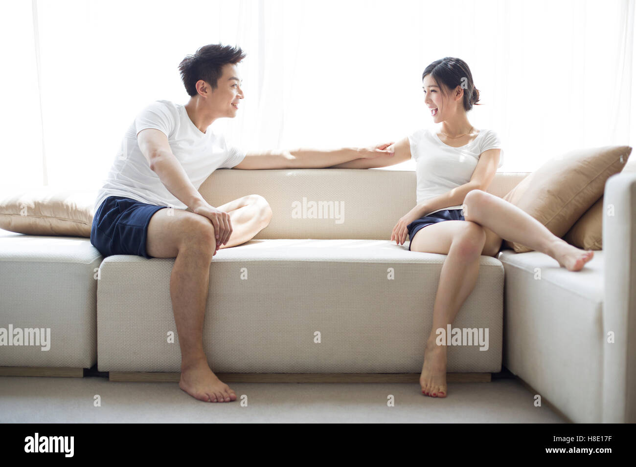 Happy young Chinese couple relaxing at home Stock Photo - Alamy