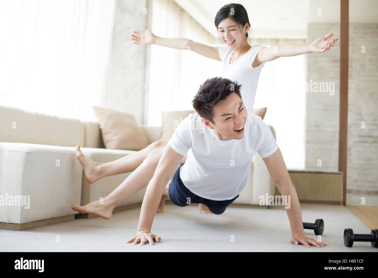 Young Chinese couple exercising at home Stock Photo - Alamy