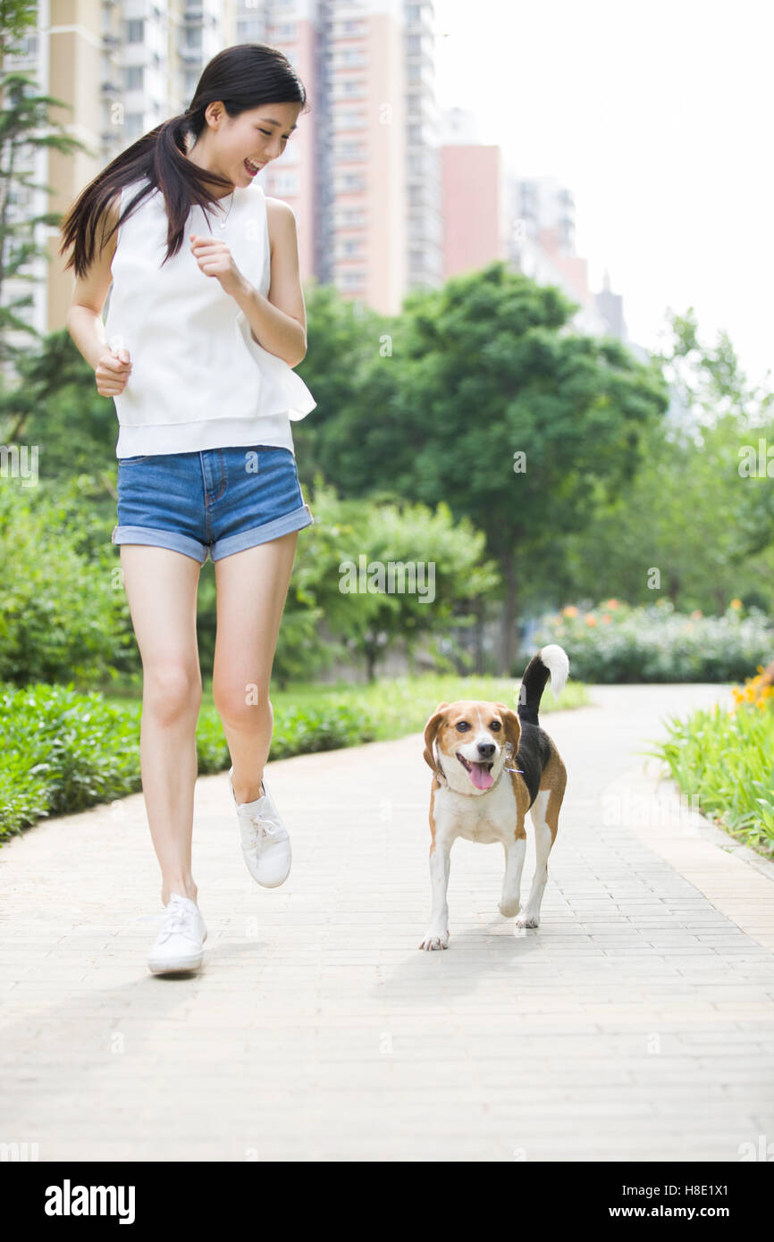 Young Chinese woman playing with a cute dog Stock Photo - Alamy