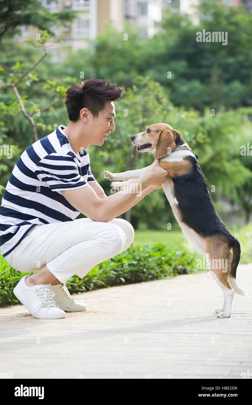 Young Chinese woman playing with a cute dog Stock Photo - Alamy