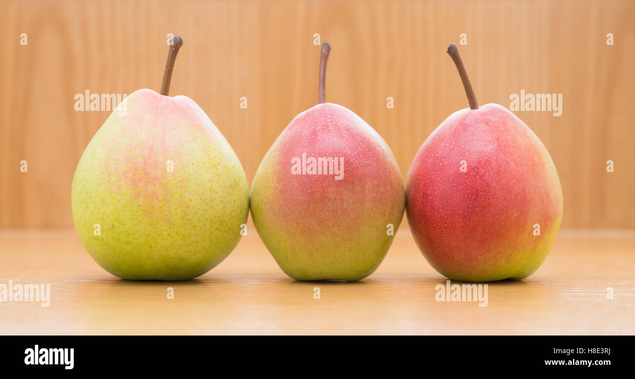 three fresh pears on a wood background Stock Photo - Alamy