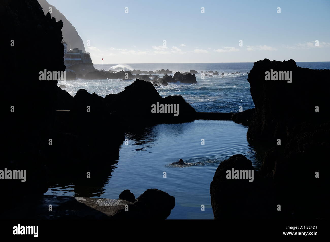 Swimmer swimming in the natural volcanic pools in Porto Moniz, Madeira ...