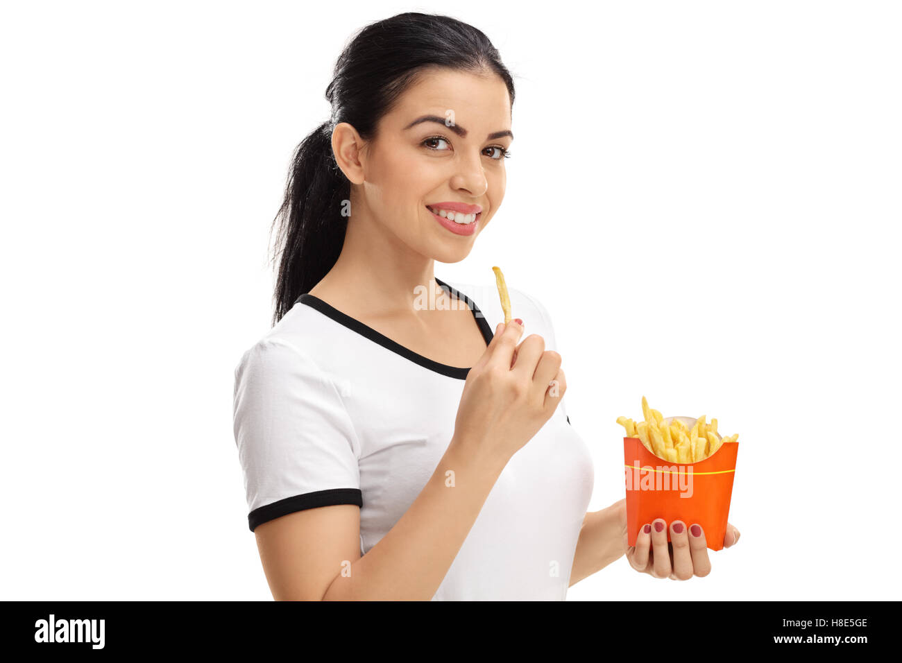 Joyful woman eating fries from a bag isolated on white background Stock ...