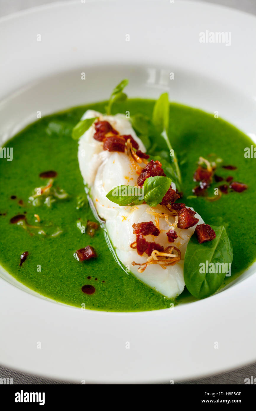 Butter poached cod with green peas, spinach and basil veloute, crispy ...