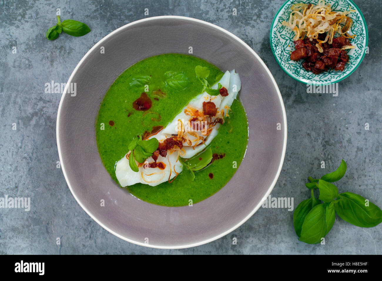 Butter poached cod with green peas, spinach and basil veloute, crispy ...