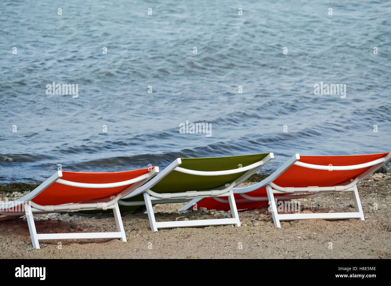 Green and red empty sun bed on the beach in a beautiful summer day ...
