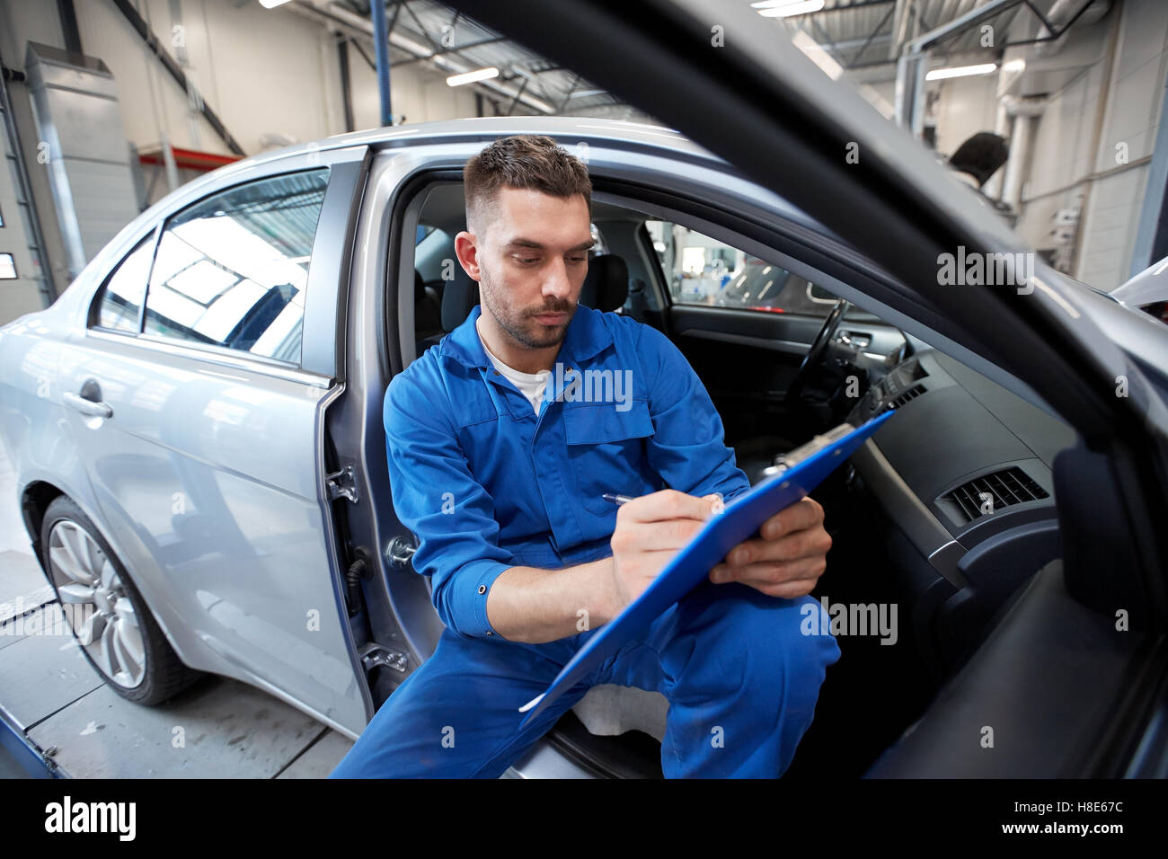auto mechanic man with clipboard at car workshop Stock Photo - Alamy