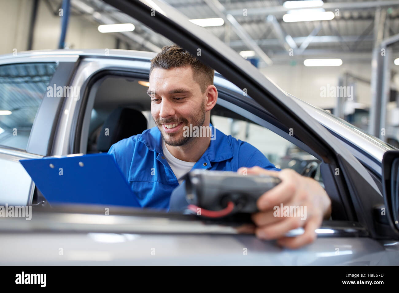 mechanic man with diagnostic scanner at car shop Stock Photo - Alamy