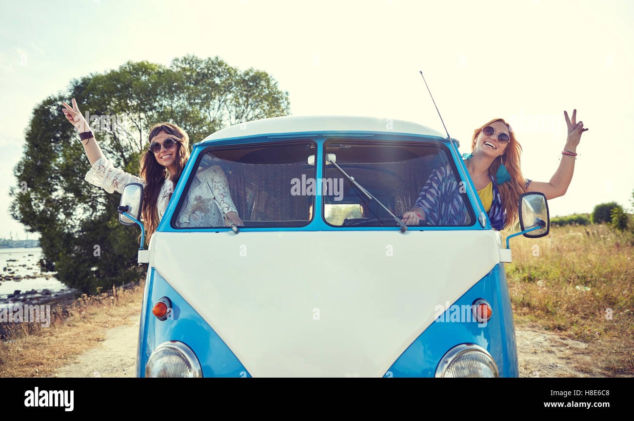 smiling young hippie women driving minivan car Stock Photo - Alamy