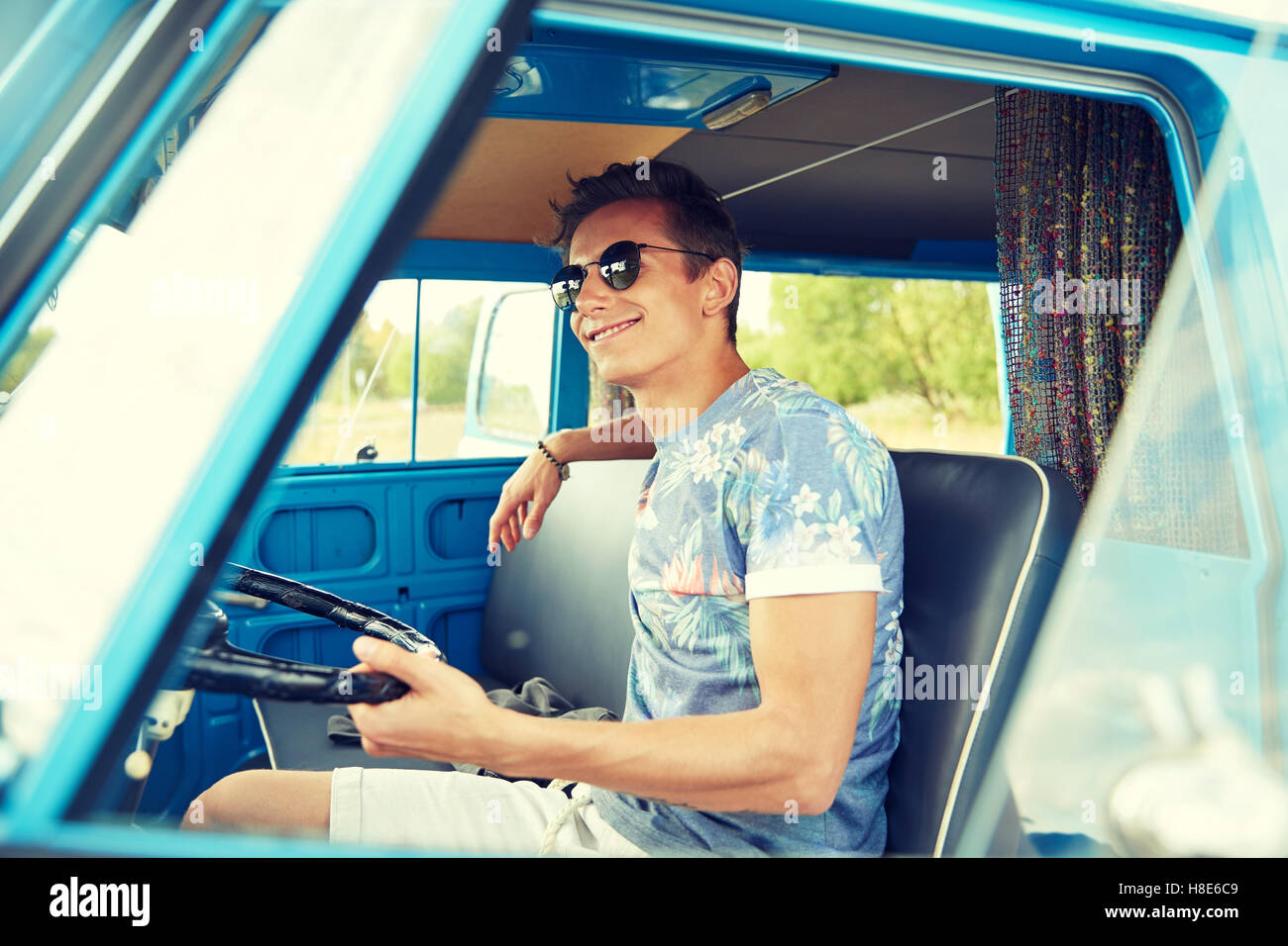 smiling young hippie man driving minivan car Stock Photo - Alamy