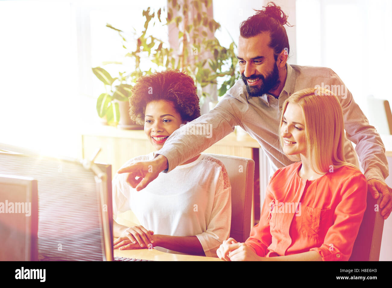 happy creative team with computer in office Stock Photo - Alamy