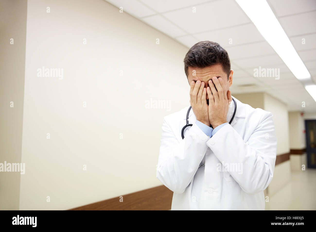 sad or crying male doctor at hospital corridor Stock Photo - Alamy