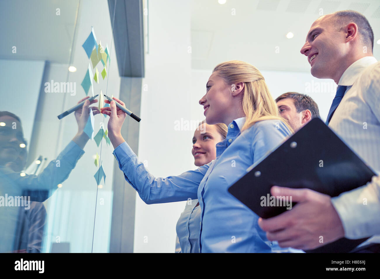 smiling business people with marker and stickers Stock Photo - Alamy