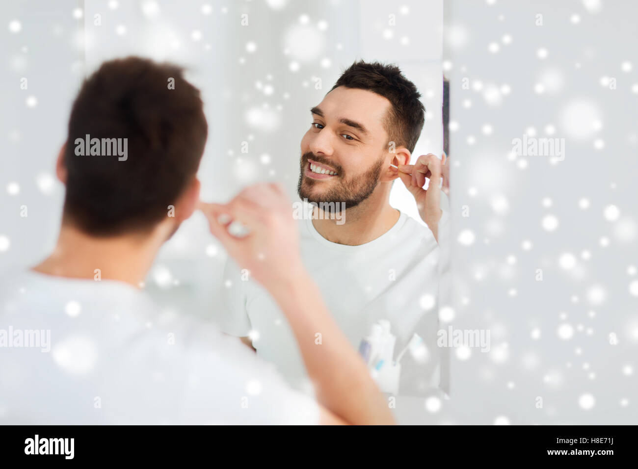 man cleaning ear with cotton swab at bathroom Stock Photo - Alamy