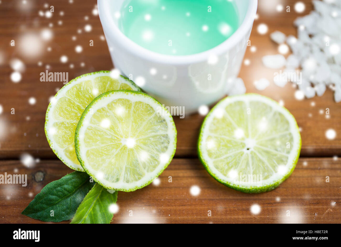 citrus body lotion in cup and limes on wood Stock Photo - Alamy