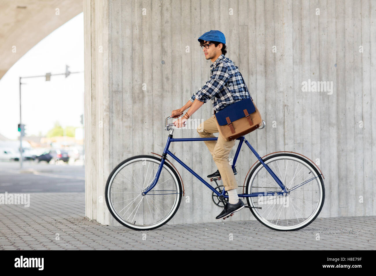 young hipster man with bag riding fixed gear bike Stock Photo - Alamy