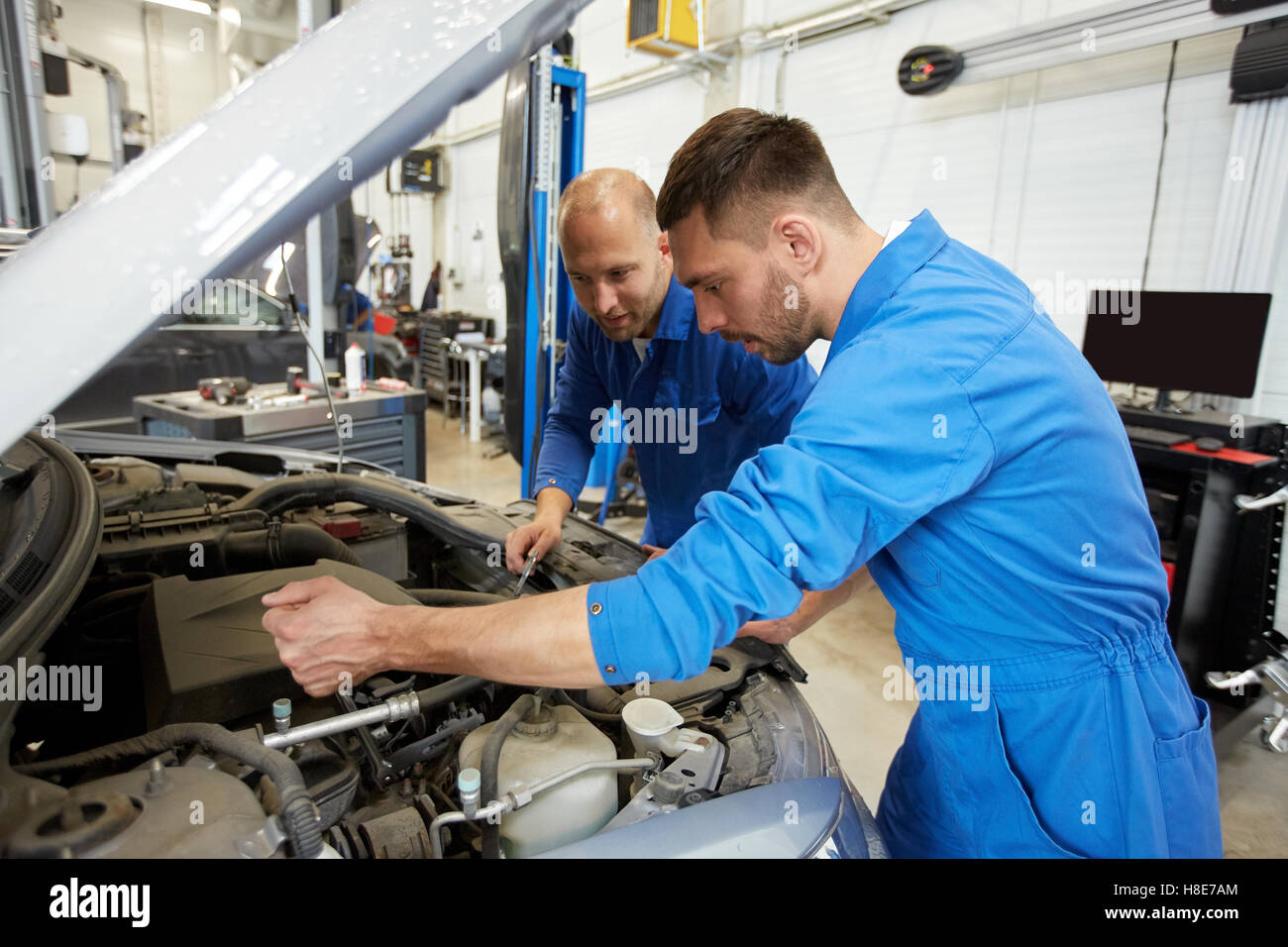 mechanic men with wrench repairing car at workshop Stock Photo - Alamy
