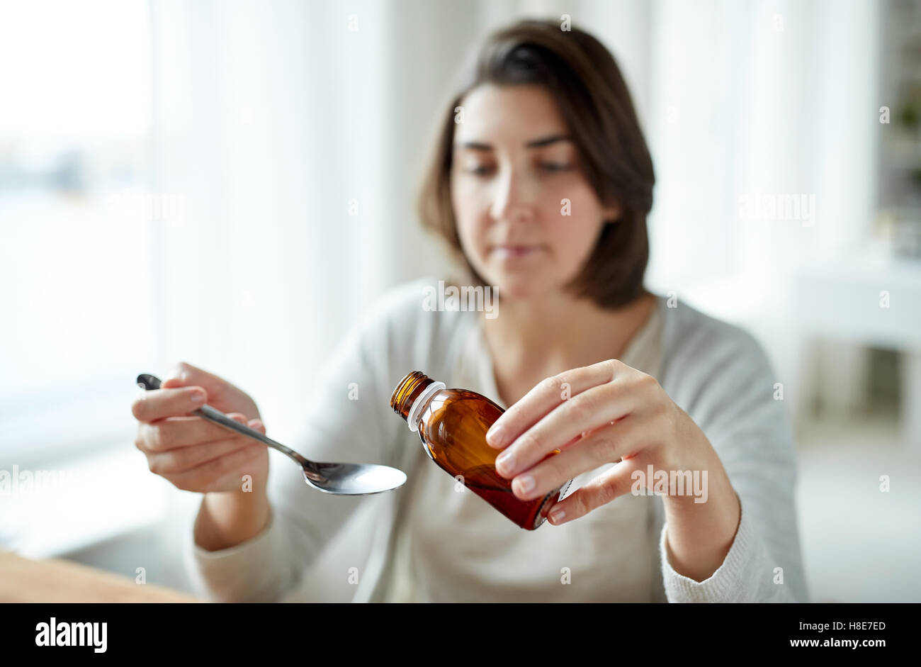 woman pouring medication from bottle to spoon Stock Photo - Alamy