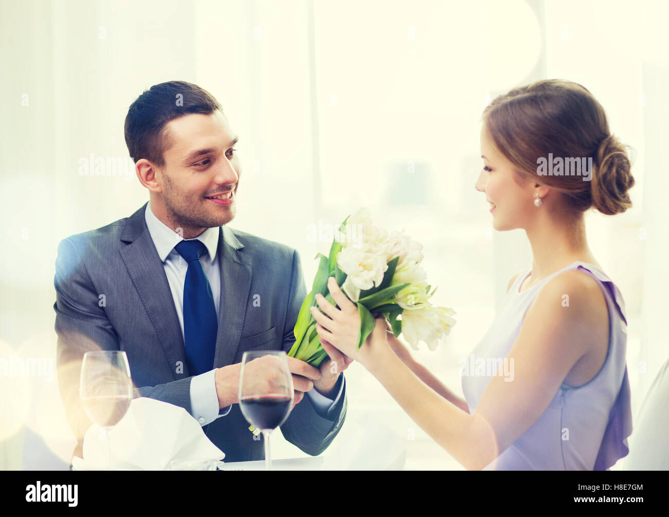 smiling man giving flower bouquet at restaurant Stock Photo - Alamy