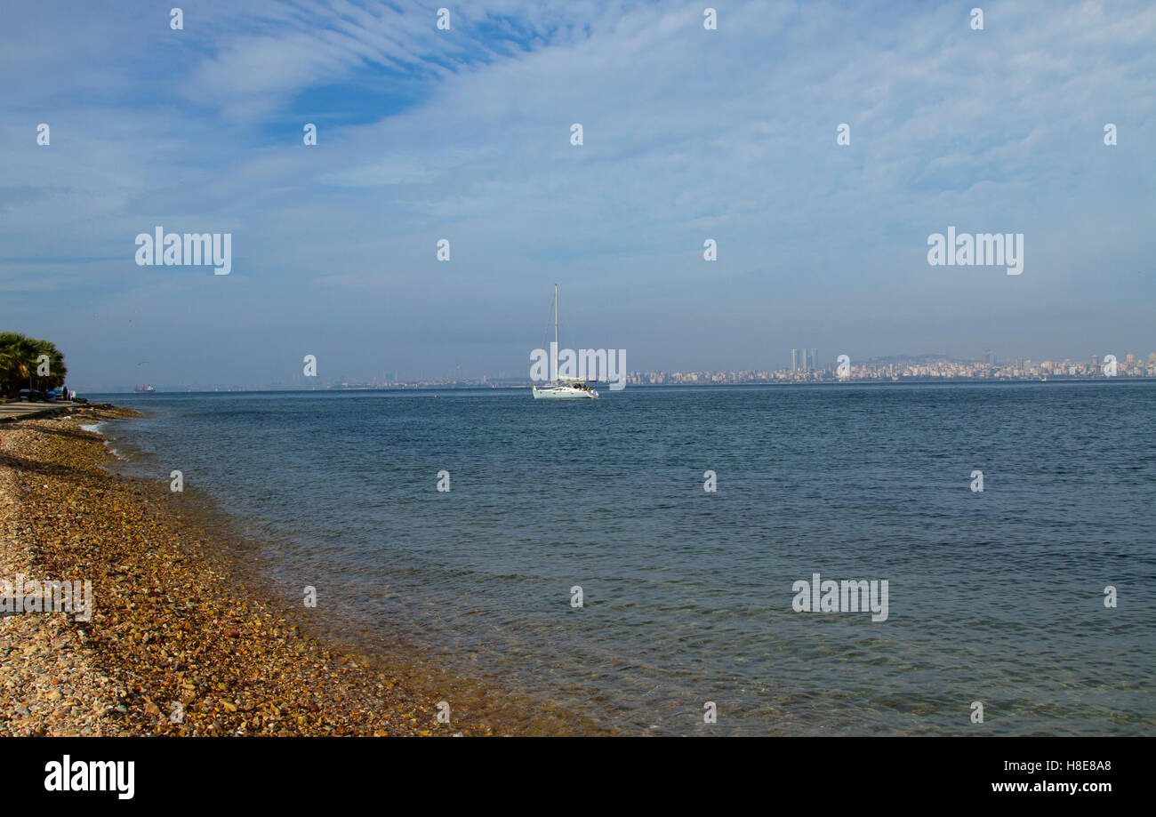 The sea bay with stones beach and sea, single yacht in the sea and ...