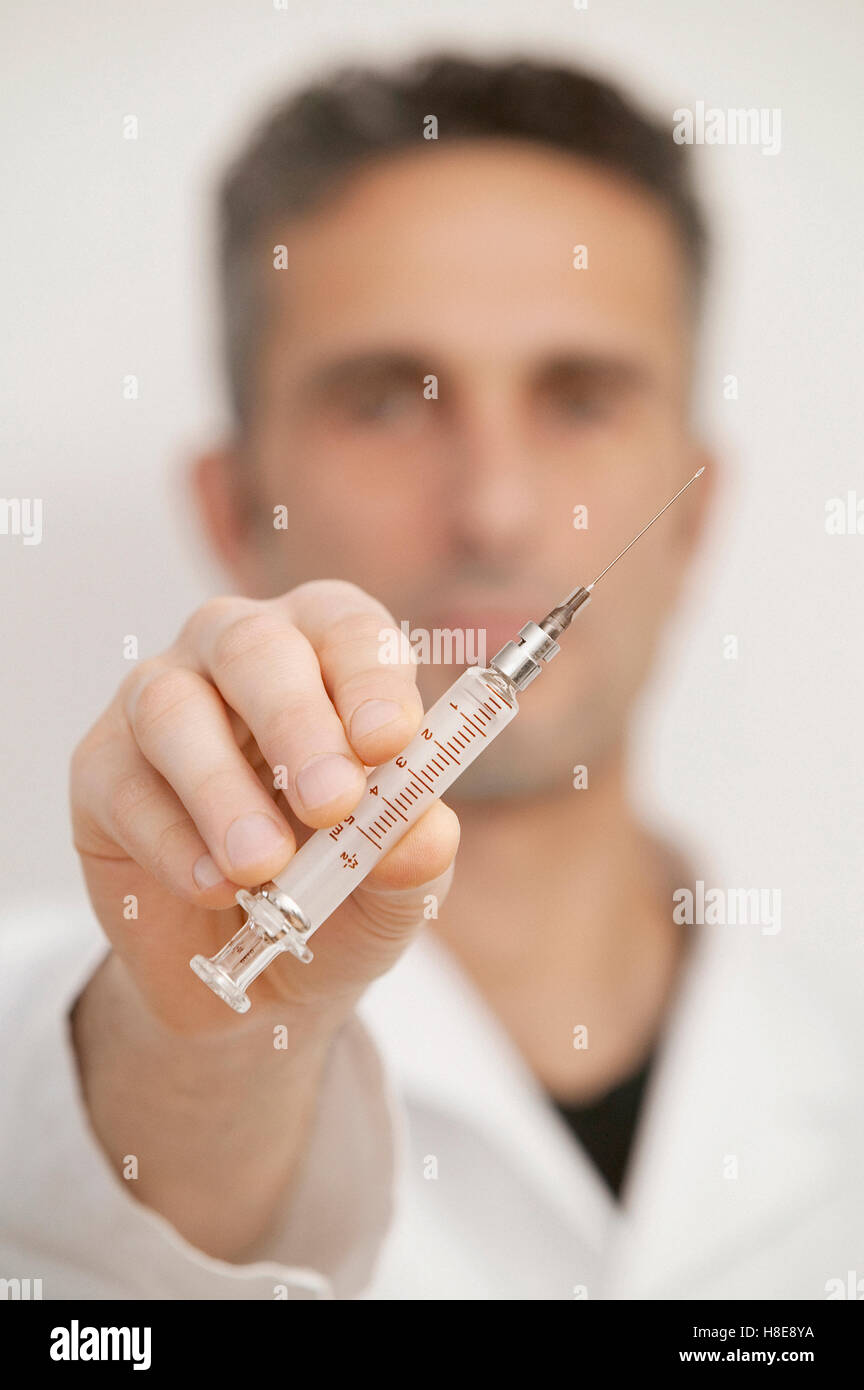 Doctor holding medical needle Stock Photo - Alamy