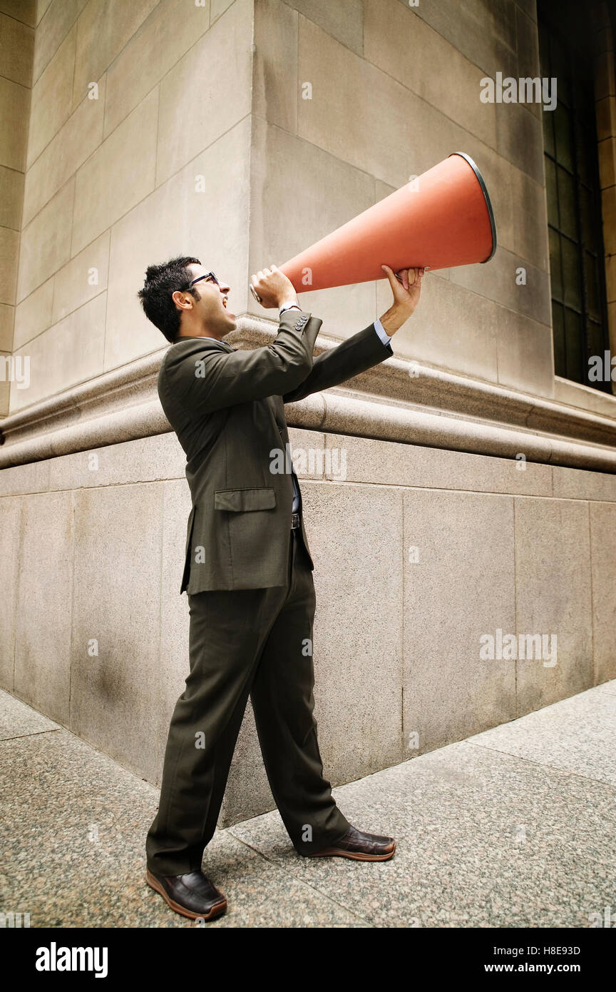 Businessman yelling into a megaphone Stock Photo - Alamy