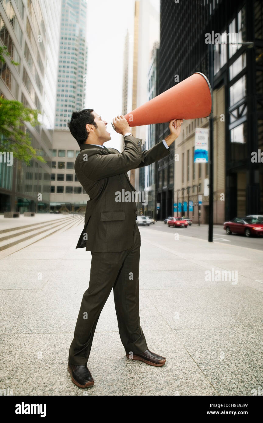 Businessman yelling into a megaphone Stock Photo - Alamy