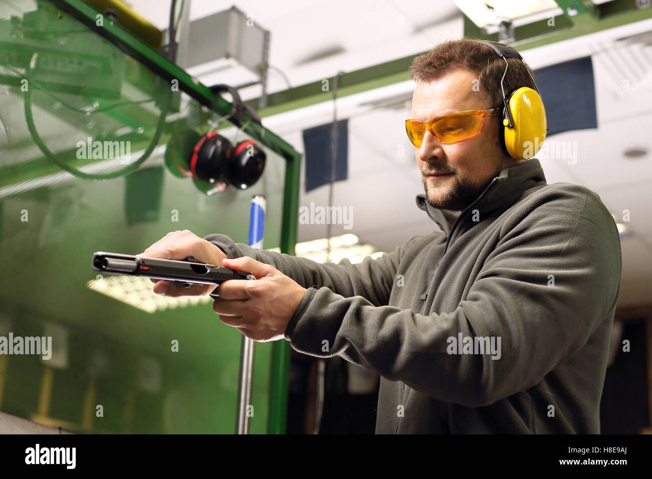 Shooting a gun at a shooting range. The man at the shooting reloads ...